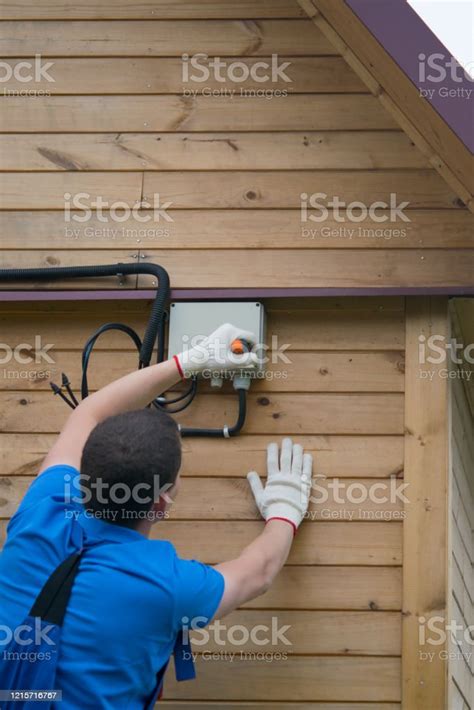 파란색 유니폼을 입은 노동자가 목조 주택의 정션 박스에서 전선을 전기에 연결하여 클로즈업 Diy에 대한 스톡 사진 및 기타 이미지 Diy 단열재 동슬라브족 Istock