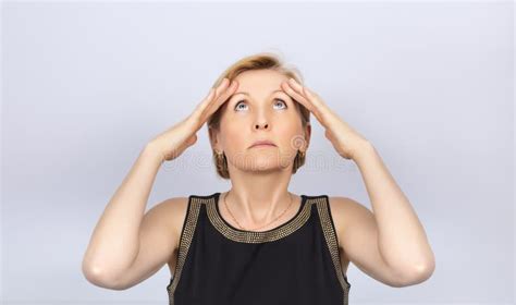 La Mujer Frota Sus Templos Con Los Dedos Y Mira Hacia Arriba Foto De Archivo Imagen De Facial