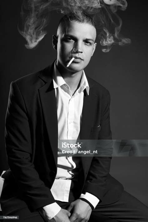 어두운 배경에 비싼 비즈니스 정장에 흡연 남자 사업가의 대조 초상화 성공적인 감정 관리자 사업가 포즈 제스처 손과 흡연 담배에