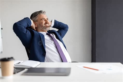 Smiling Middle Aged Businessman Leaning Back In Chair At Workplace In Office Stock Image Image
