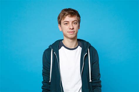 스튜디오에서 파란색 벽 배경에 고립 된 캐주얼 복장에 매력적인 즐거운 젊은 남자의 초상화 사람들은 진심으로 감정 라이프 스타일 개념입니다 복사 공간을 모의 합니다 광고 영역