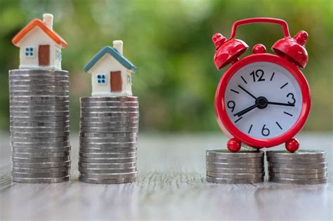 동전과 동전의 더미에 빨간색 알람 시계에 집 금융 및 은행 개념 부동산 투자 및 금융 개념에 대한 은행의 금융 저축 비즈니스