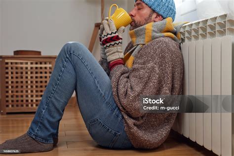 추운 겨울날 에너지 및 가스 위기 차가운 방 난방 문제에 실내에서 모자 스웨터 손 장갑을 낀 남자 가을에 대한 스톡 사진 및 기타 이미지 Istock