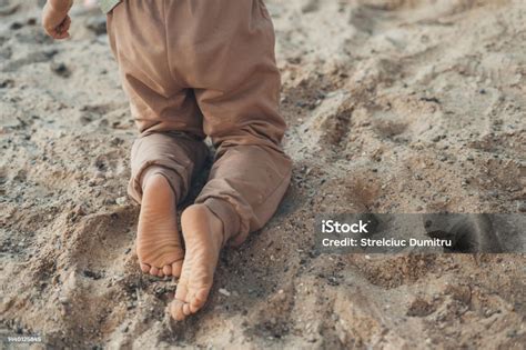 화창한 아침에 모래에서 놀고 있는 소년의 다리 여름 야외 활동 활동 여름 방학 재미 해변에서 즐거운 시간을 보내는 아이 여름과