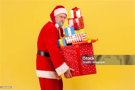 크리스마스 축하를 준비 선물로 많은 상자를 들고 산타 클로스 의상을 입고 회색 수염을 가진 피곤 한 노인의 초상화 성탄절 선물에