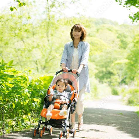 赤ちゃんの乗るベビーカーを押す母親 の ストック写真とロイヤリティフリーの画像 Pic 260957583