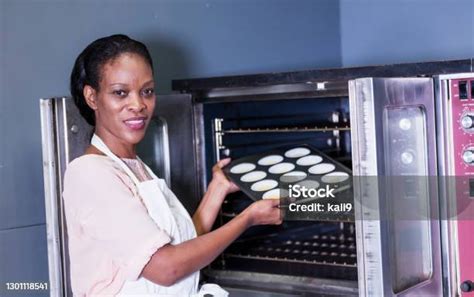 빵집에서 일하는 아프리카계 미국인 여성컵케이크 만들기 아프리카계 미국 민족에 대한 스톡 사진 및 기타 이미지 아프리카계 미국 민족 오븐에 굽기 한 명의 여자만