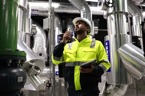 건물 지하에 있는 에어컨의 냉각 시스템을 검사하기 위해 작업하는 에너지 엔지니어의 초상화 기계공에 대한 스톡 사진 및 기타