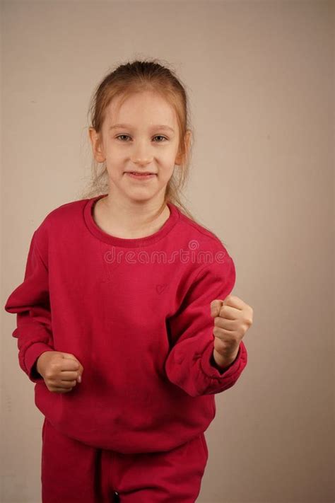 A Small Red Haired Girl Stands With Her Fists Clenched Emanating Fierce Determination Her
