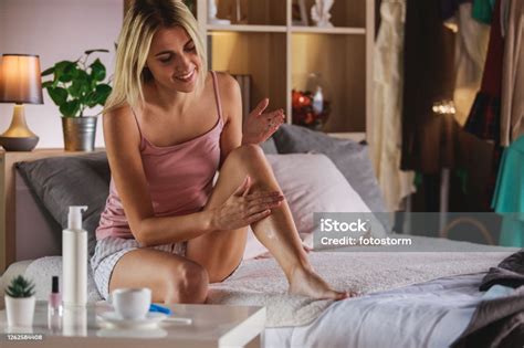 그녀의 다리에 보습 로션을 적용 미소 젊은 여자의 전체 길이 샷 보습제에 대한 스톡 사진 및 기타 이미지 보습제 사람 다리 침대 Istock