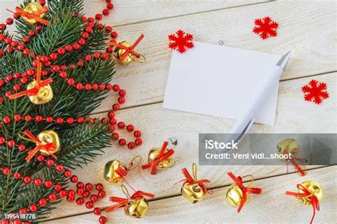 빨간 구슬 화환과 황금 크리스마스 공 전나무 지점 근처 나무 테이블에 빈 인사 카드와 볼펜 크리스마스와 새해 거룩한 날 0명에 대한 스톡 사진 및 기타 이미지 Istock