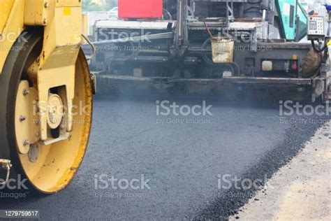 아스팔트 파버 기계와 건설 현장에서 새로운 도로를 만드는 스트림 도로 롤러와 함께 작업 도로 롤러 0명에 대한 스톡 사진 및