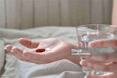 청녀의 손을 클로즈업한 모습 정제 또는 알약과 물 한 잔을 들고 침대에 소녀 텍스트 공간이있는 진통제 흐린 배경 가정 생활에 대한 스톡 사진 및 기타 이미지 Istock