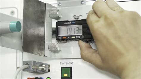 electronic digital caliper on white dashboard scene industrial background with a male hand