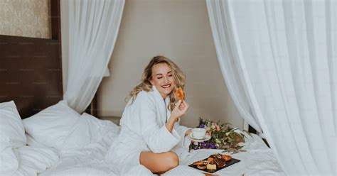 흰 가운을 입은 여자가 침대에 앉아 있다 사진 Unsplash의 여자 이미지