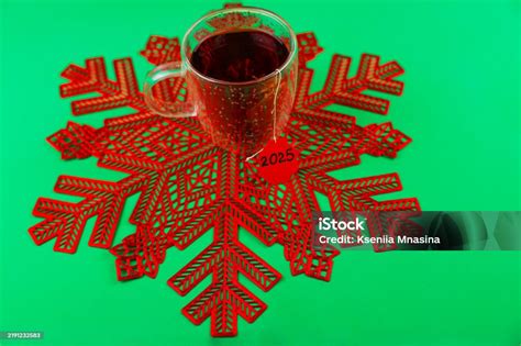 크로마키의 녹색의 밝은 배경에는 빨간색 투각 눈송이 투명한 차 한 잔이 있는 냅킨 텍스트를 위한 공간이 있는 새해 복 많이 받으세요 레이블이 있습니다 0명에 대한 스톡 사진