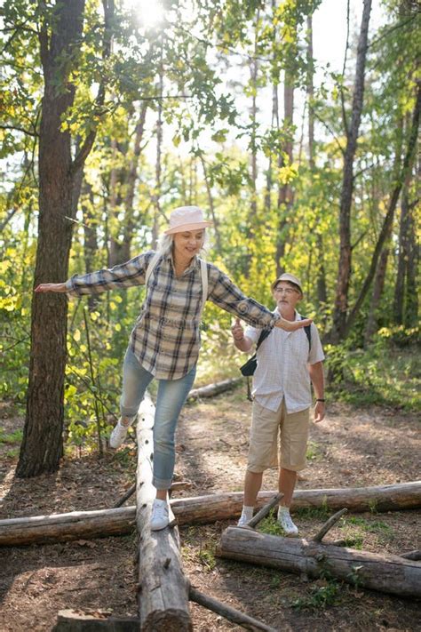 Mujer Madura Divirti Ndose Mientras Camina Sobre La Ra Z Del Rbol Imagen De Archivo Imagen