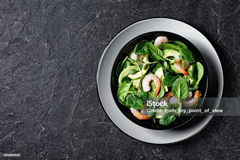 아기 시금치 잎 신선한 해바라기 콩나물 올리브 오일 드레싱 칠리 플레이크와 아보카도 새우의 건강한 샐러드는 어두운 배경 상단 보기 클로즈업 복사 공간에 접시에 제공 0명에