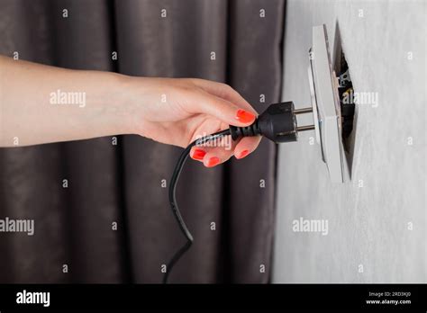 The Girl Removes The Electrical Plug From The Socket And Breaks The Socket Out Of The Socket