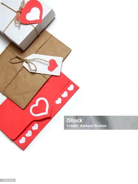 활과 붉은 종이 하트가 달린 라벨이 달린 꼬기와 묶인 선물 흰색 배경에 하트가 달린 빨간 봉투에 담긴 러브 레터가 고립되어 있습니다 사랑 발렌타인 여성의 날 관계 낭만적 인
