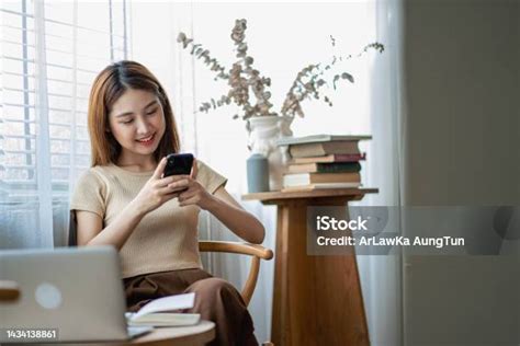 커피 숍에서 스마트 폰과 노트북을 가지고 노는 아시아 여성 인터넷 서핑 채팅 블로깅을하는 젊은 여성 전화를 들고 화면을 보는 여자 비즈니스 캐주얼에 대한 스톡 사진 및 기타