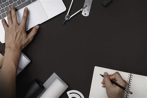 건축가 드로잉 건축 프로젝트 롤 청사진 엔지니어링 도구 사무용품 및 노트북 컴퓨터의 손은 텍스트에 대한 복사 공간 디자이너 개념을위한 작업 공간과 검은 테이블에 개념에 대한