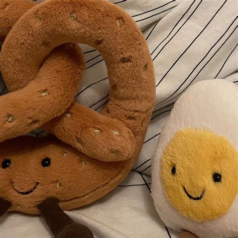 Two Stuffed Animals Laying Next To Each Other On A Bed