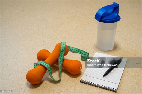 피트니스 배경 아령 한 켤레 펜이있는 노트북 진행 상황을 추적하는 측정 테이프 및 물 한 병 검역 중에 집에서 훈련을위한 액세서리 세트 0명에 대한 스톡 사진 및 기타