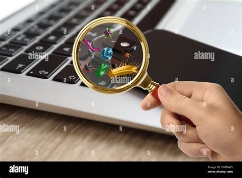 Woman With Magnifying Glass Detecting Microbes On Laptop Keyboard