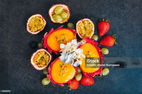 드래곤 과일 빨간색 잘 익은 딸기와 어두운 배경에 포도의 조각 채식주의 호텔 샐러드를 만들기 위한 신선한 과일의 집합입니다 영양과 비타민 개념 0명에 대한 스톡 사진 및