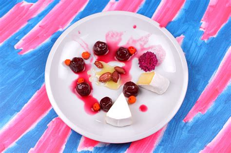 치즈 카망베르 흰 접시 팝 아트 과일 및 파란 장미 배경 땅콩 꿀 통조림된 체리 치즈 소스를 접시에 소스 0명에 대한 스톡 사진