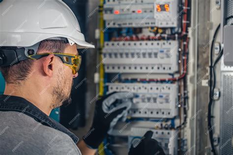 퓨즈가 있는 배전반에서 일하는 전기 기술자 무료 사진
