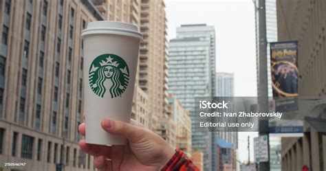 캐나다 토론토 2023년 5월 6일 스타벅스 컵을 손에 들고 상징적인 도시 배경 스타벅스가 친숙한 편안함을 제공하는 동안 도시의 번잡함이 흐릅니다 대도시 생활의 상징적인
