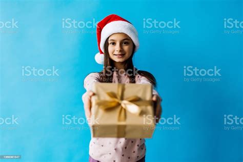 파란 배경에 불빛 위에 선물 상자를 들고 산타 도우미 모자에 미소 십대 소녀 겨울에 대한 스톡 사진 및 기타 이미지 겨울