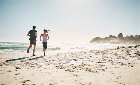 조깅을하거나 지구력을하는 커플은 여름 동안 멋진 바다와 복사 공간이있는 자연 배경으로 해변에서 함께 달립니다 야외에서 심장 체력을 위해 운동하는 남성과 여성에게 적합