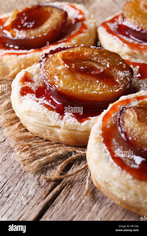 Cakes Of Puff Pastry With Plums Macro On An Old Table Vertical Stock