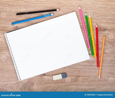 Чистый лист бумаги и красочные карандаши на деревянном столе Стоковое Изображение изображение