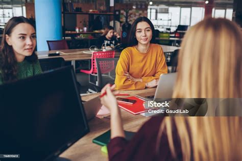 현대 기술을 사용하여 동료에게 정보와 전략을 설명하는 여성 상사의 백뷰 데스크톱에 앉아 있는 프로젝트에 대한 브레인스토밍