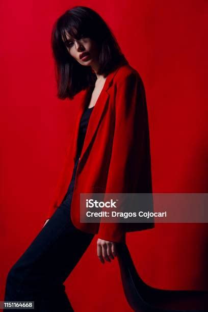빨간 바탕에 고립 된 붉은 양복의 자에 서 있는 스튜디오에서 포즈를 취한 프로필에 있는 젊은 여자의 초상화 색상 묘사에 대한 스톡 사진 및 기타 이미지 Istock