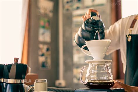 음료 커피 포트는 뜨겁고 모닝 카페 집에서 일할 때 업무용 책상 위의 컵에 김이 나는 커피를 붓는 손 여과에 대한 스톡 사진 및