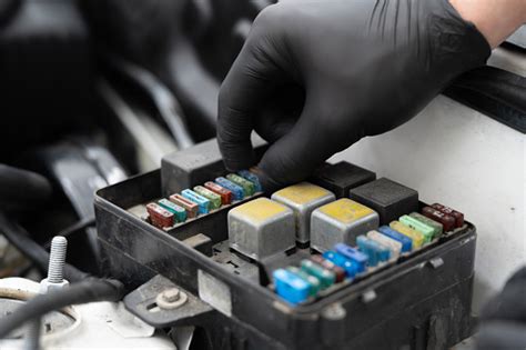 자동차 정비소에서 차량 퓨즈 박스의 퓨즈를 검사하고 교체하는 전문 자동차 정비사 25 29세에 대한 스톡 사진 및 기타 이미지 25 29세 건강 진단 검사 보기