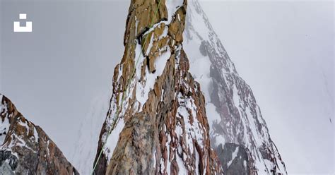 빨간 재킷과 검은 바지를 입은 사람이 낮에 눈 덮인 땅에 서 있습니다 사진 Unsplash의 무료 브라이트호른 이미지