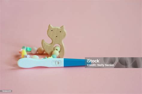 구슬과 임신 테스트와 나무 아기 이빨 나무 장난감 고양이 고립 된 분홍색 배경과 미니멀 플랫 누워 어린이와 부모를 즐겁게장난감 나무와 아기 실리콘 치자 0명에 대한 스톡