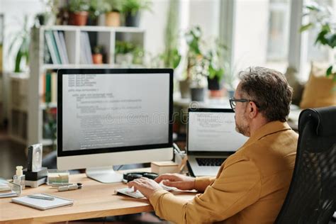 Side View Of Mature Confident Businessman Decoding Data On Computer