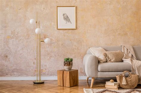 디자인 회색 소파 나무 커피 테이블 선반 큐브 카펫 등나무 푸프 식물 사진 프레임 테이블 램프와 가정 장식우아한 액세서리와 거실