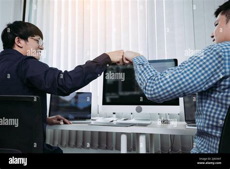 Asian Employee Software Developers Celebrate Success Project By Fist Bump In Office Room Stock