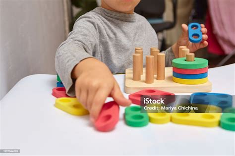 아이는 선별기를 수집합니다 아이들을위한 교육 논리 장난감 아이들의 손을 클로즈업 몬테소리 어린이 발달 게임 흰색 배경에 여러