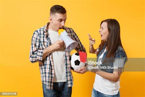 생상 재미 미친 커플 여자 남자 축구 팬 들 비명 손실의 화가 축구 공 레드 카드 노란 배경에 고립 된 확성기 좋아하는 팀의 목표 스포츠 가족 라이프 스타일 개념입니다 T