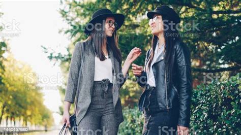 행복 한 여자와 채팅 야외 쇼핑몰에서 일을 논의 하는 밝은 쇼핑백을 들고 길거리에 서 웃 고 여자는 세련 된 의류와 안경을 쓰고 있다 2명에 대한 스톡 사진 및 기타 이미지