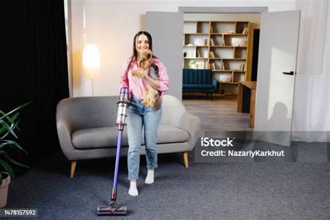 진공 청소기와 개를 손에 들고 거실에서 진공 청소기로 청소하는 여자 가사 집안일에 대한 스톡 사진 및 기타 이미지 가사